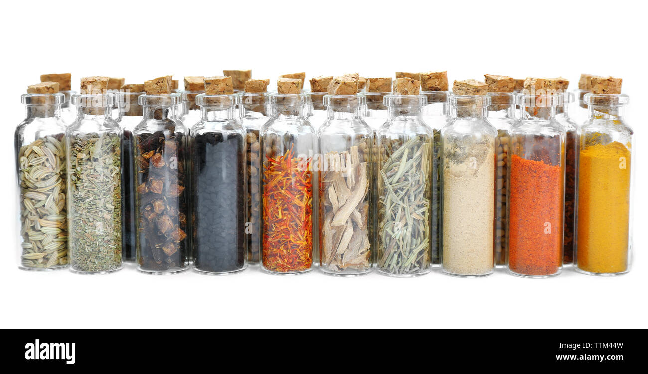 Assorted dry spices in glass bottles on white background Stock Photo ...