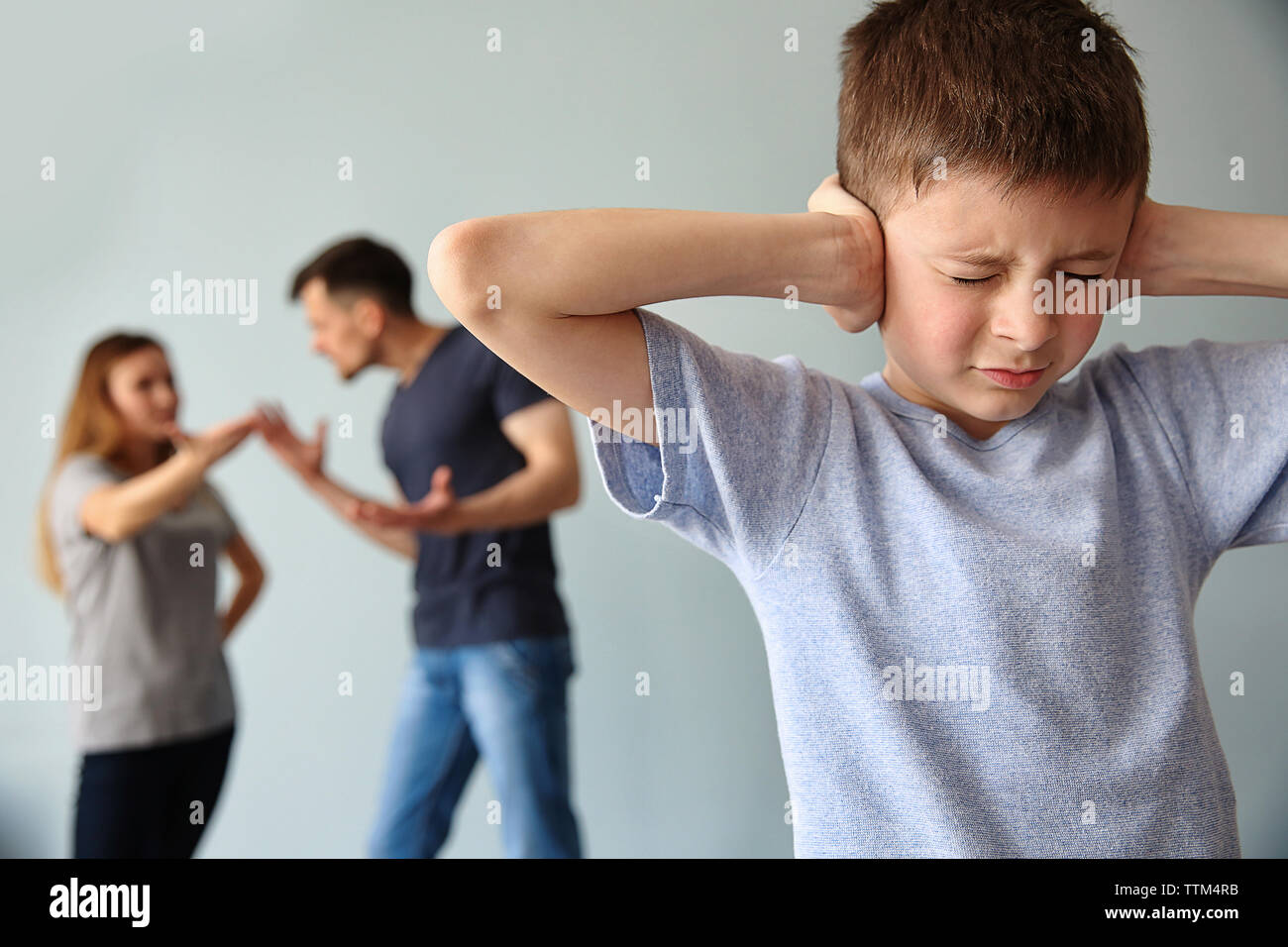 Family problems concept. Boy closing his ears while parents abusing ...