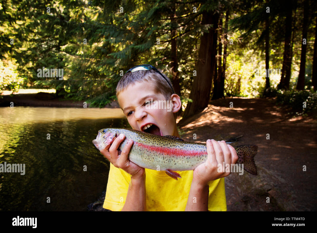 Boy pretending to bite fish Stock Photo - Alamy