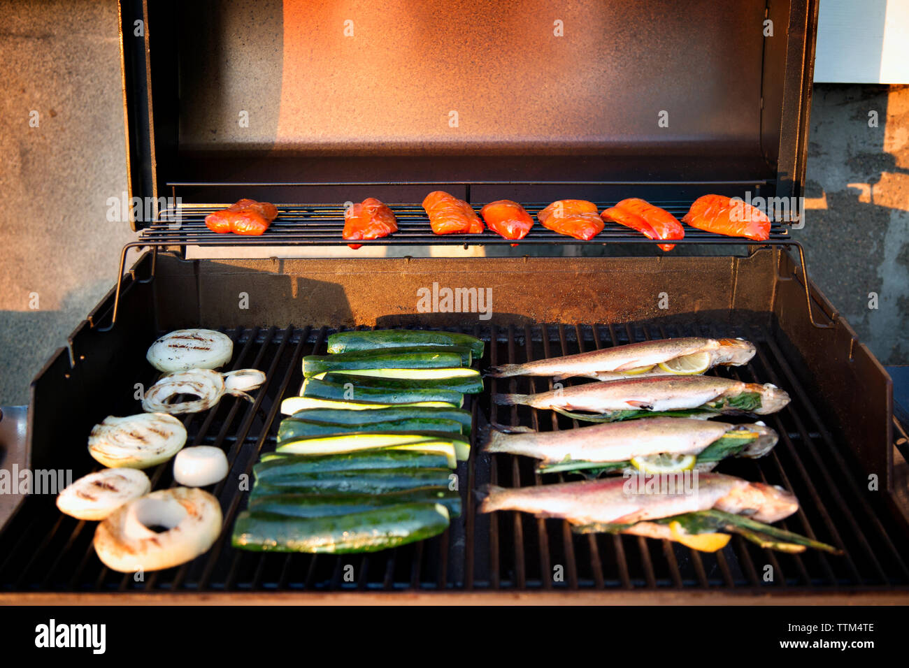 Fish and vegetables being grilled Stock Photo - Alamy