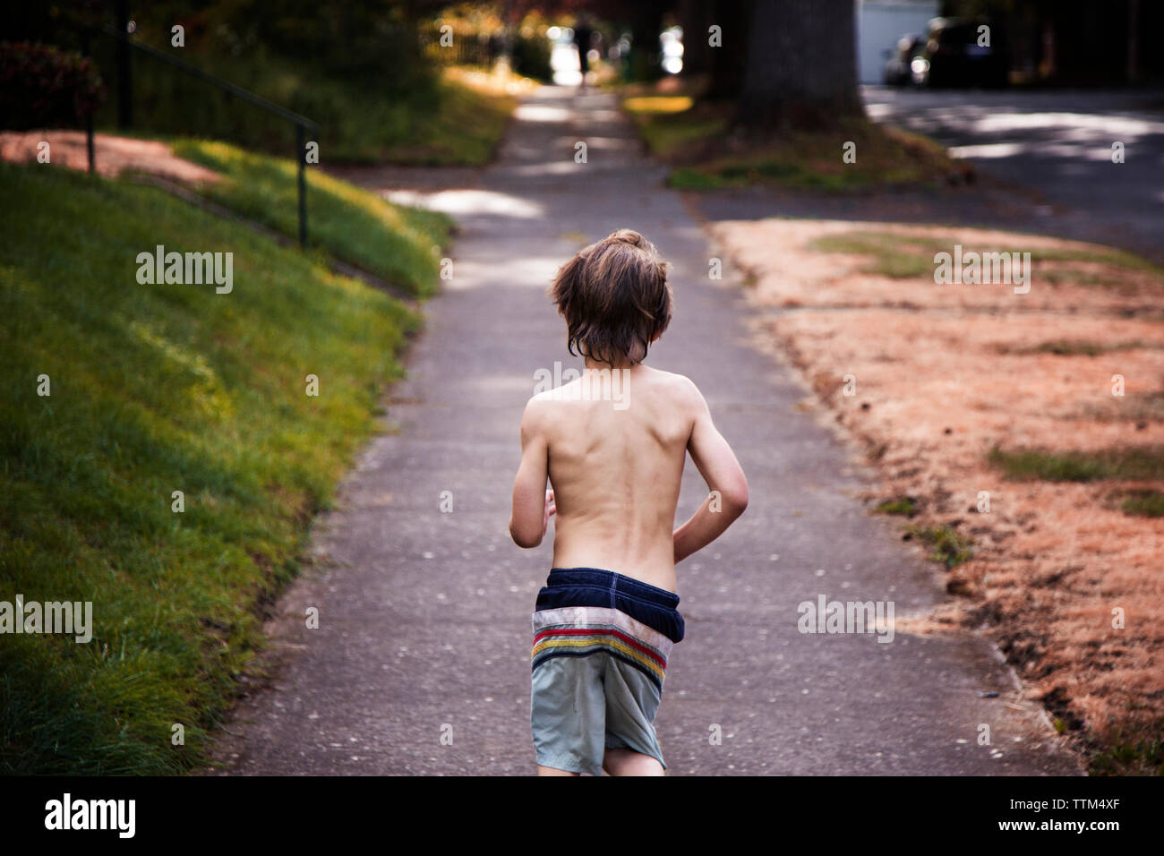 Rear view of shirtless boy running Stock Photo - Alamy