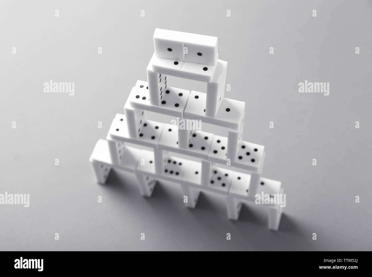 Tower of dominoes on grey background Stock Photo - Alamy