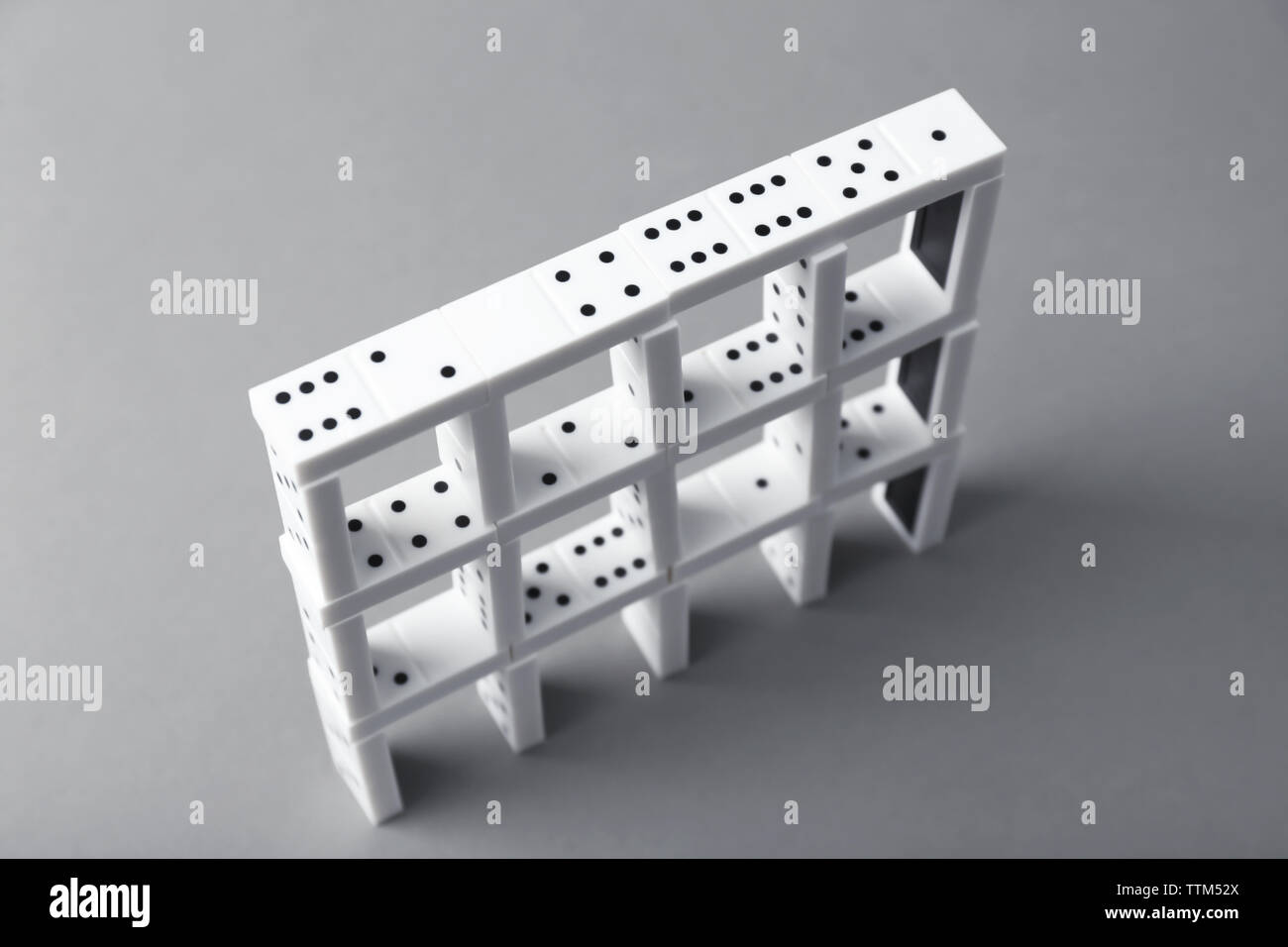 Tower of dominoes on grey background Stock Photo - Alamy