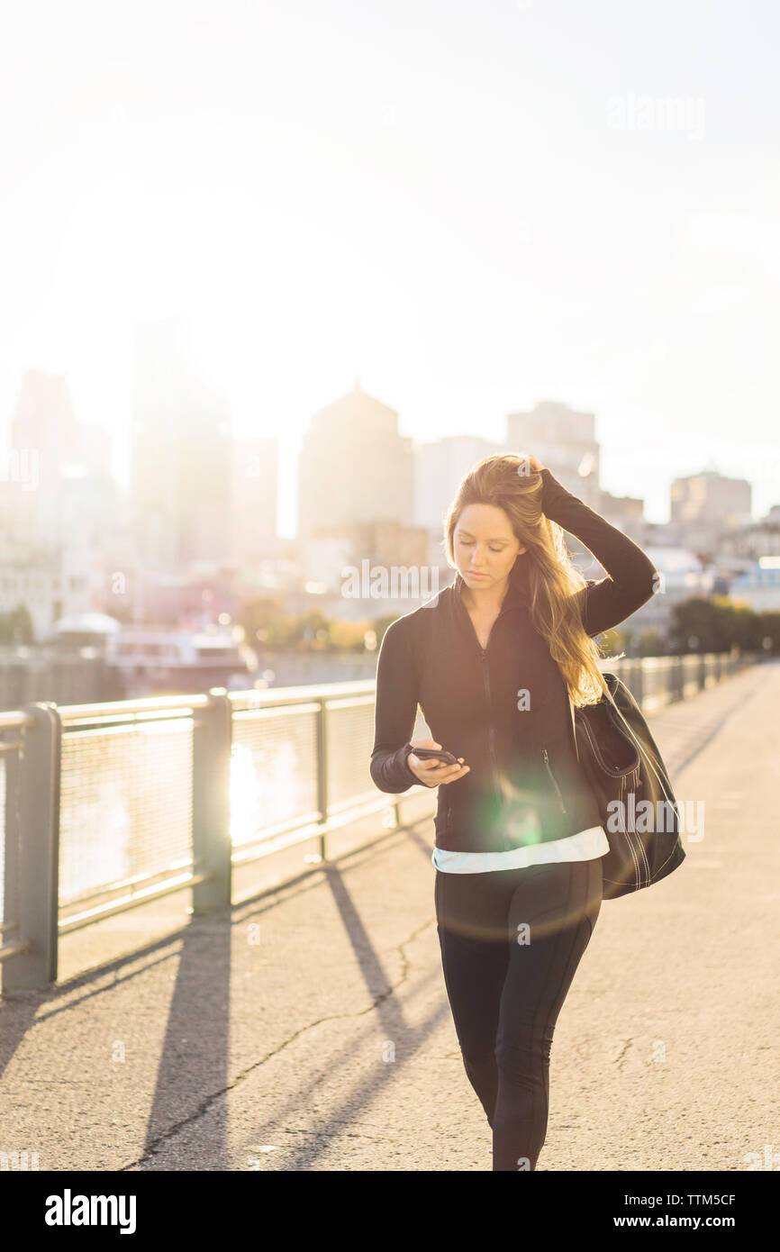 Woman walking holding mobile phone hi-res stock photography and images ...