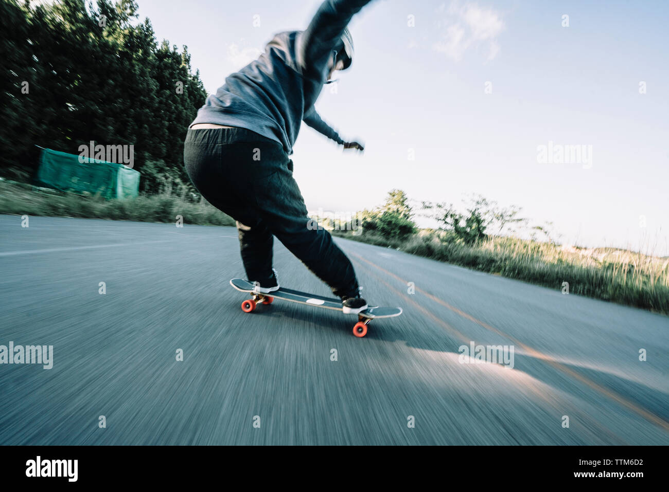 Rear view of man skateboarding on road Stock Photo - Alamy