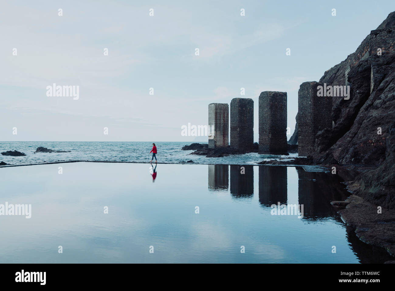 Side view of woman walking by swimming pool against sea and sky Stock ...