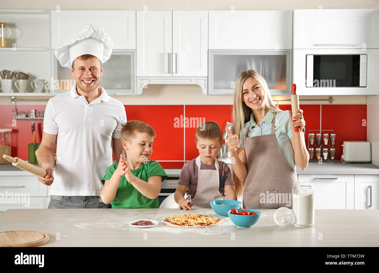 Happy family making pizza in kitchen Stock Photo - Alamy