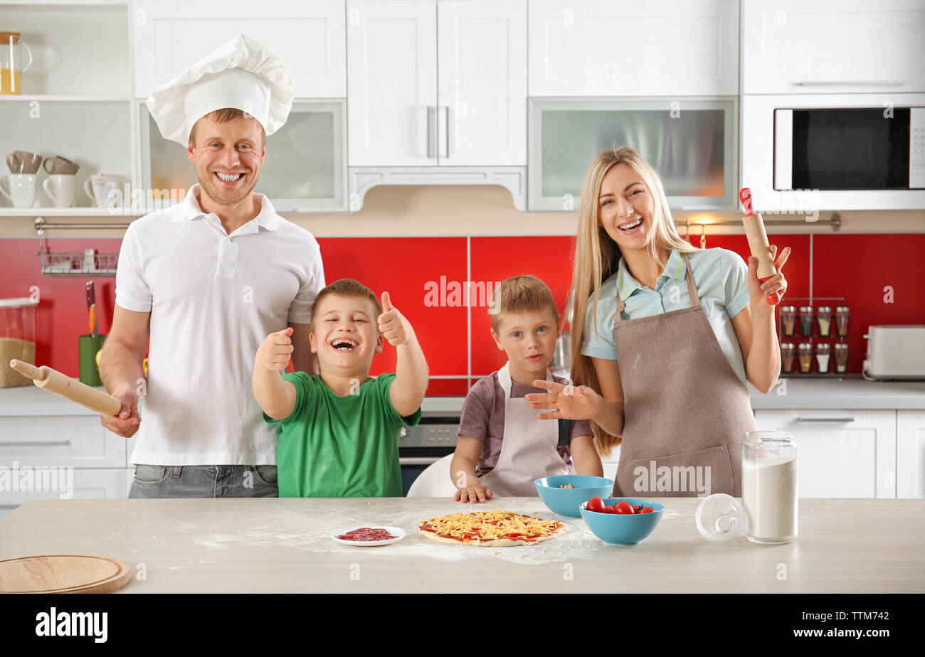 Happy family making pizza in kitchen Stock Photo - Alamy