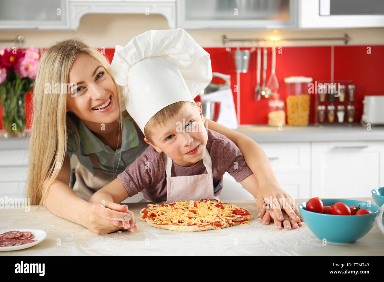 Happy family making pizza in kitchen Stock Photo - Alamy