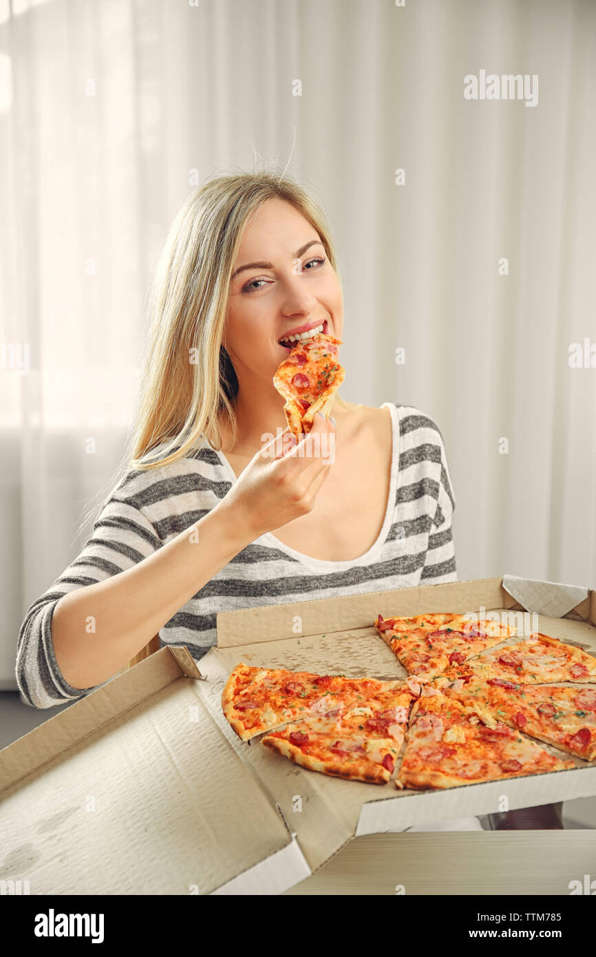Beautiful woman eating pizza Stock Photo - Alamy