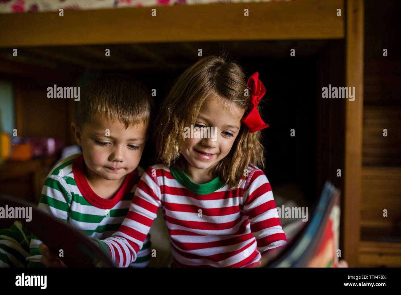 Siblings reading book home hi-res stock photography and images - Alamy