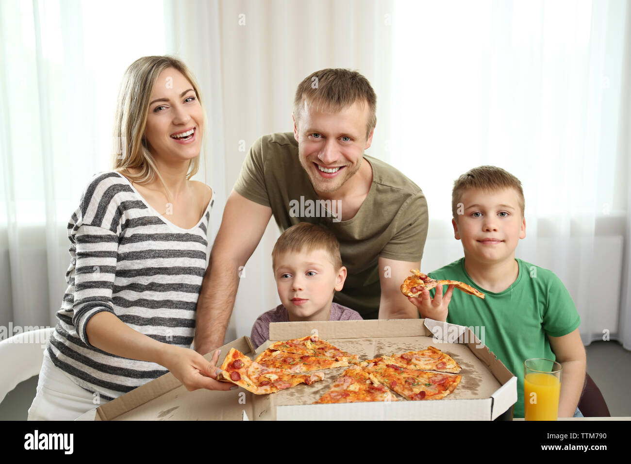 Happy lovely family eating pizza Stock Photo - Alamy