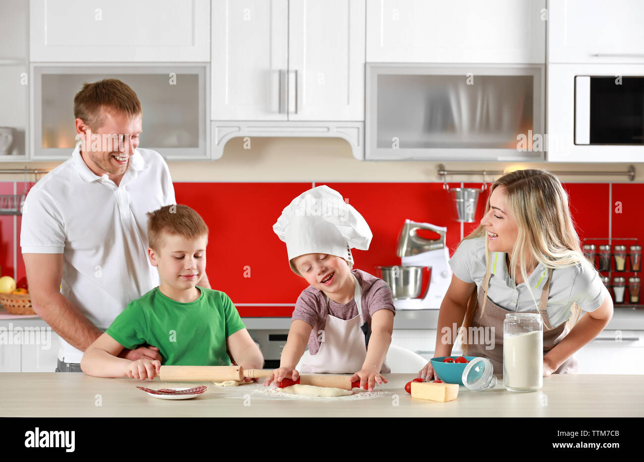 Happy family making pizza in kitchen Stock Photo - Alamy