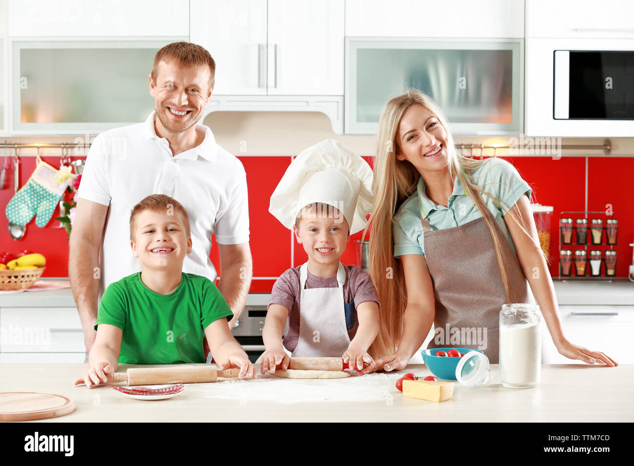 Happy family making pizza in kitchen Stock Photo - Alamy