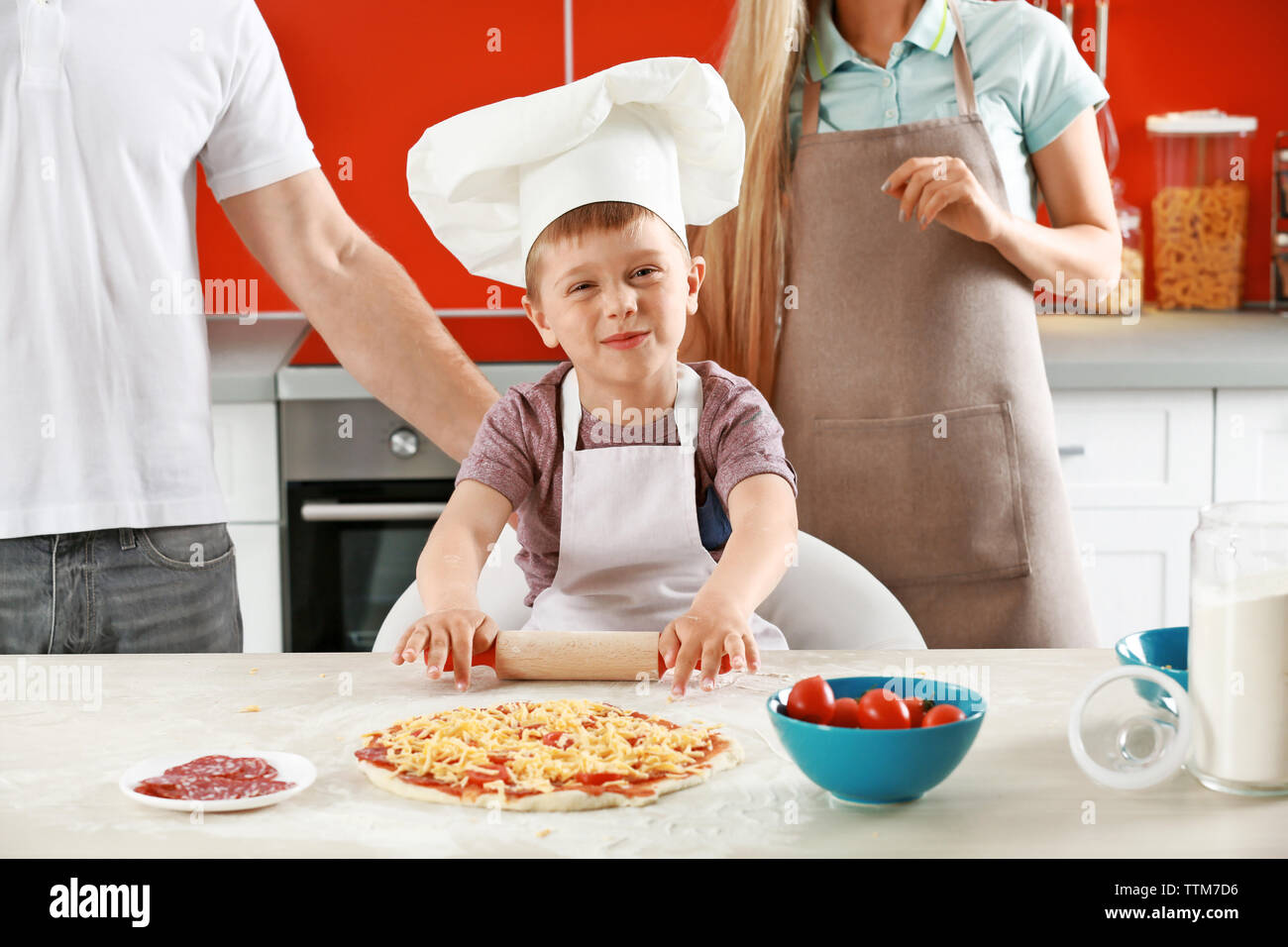 Happy family making pizza in kitchen Stock Photo - Alamy