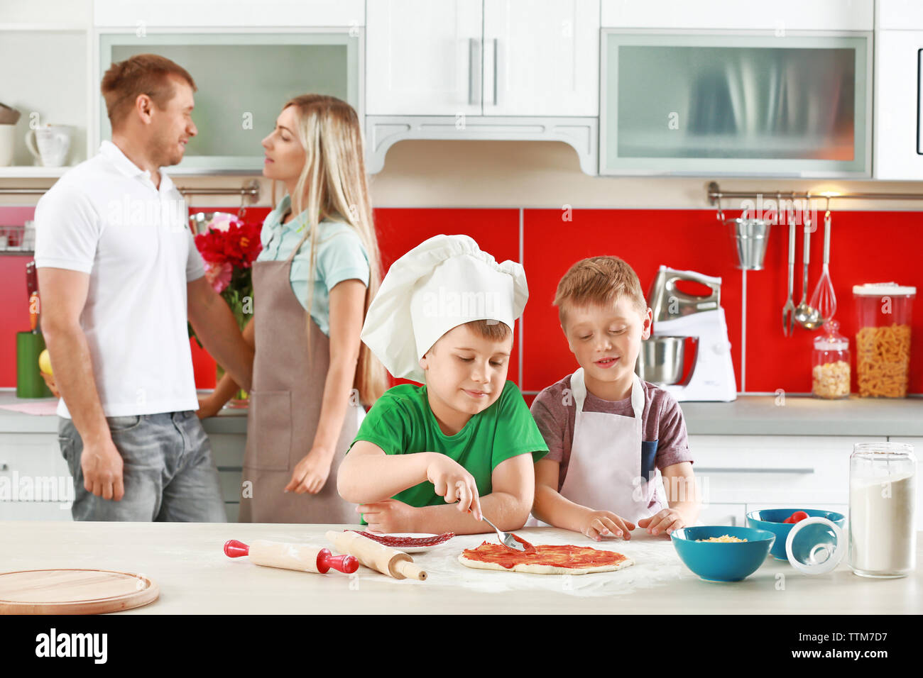 Happy family making pizza in kitchen Stock Photo - Alamy
