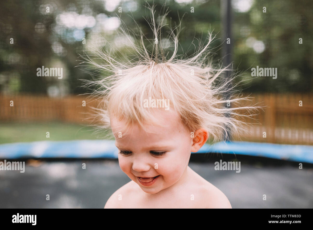 Toddler girl with wild static hair looking down Stock Photo - Alamy