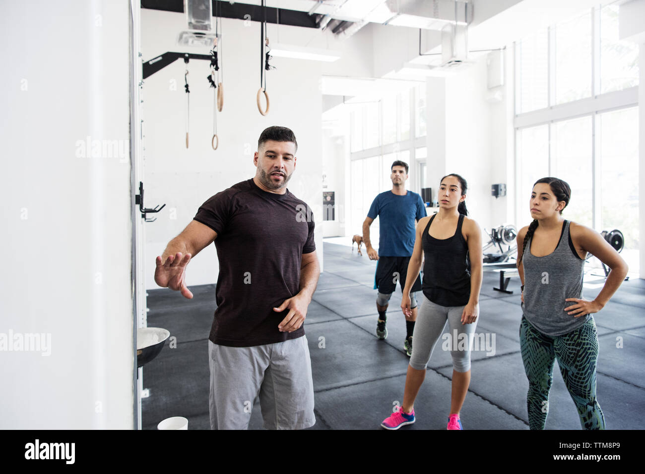 Instructor explaining athletes in crossfit gym Stock Photo - Alamy