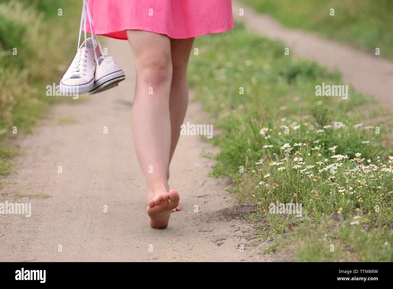 Woman walking on road path Stock Photo - Alamy