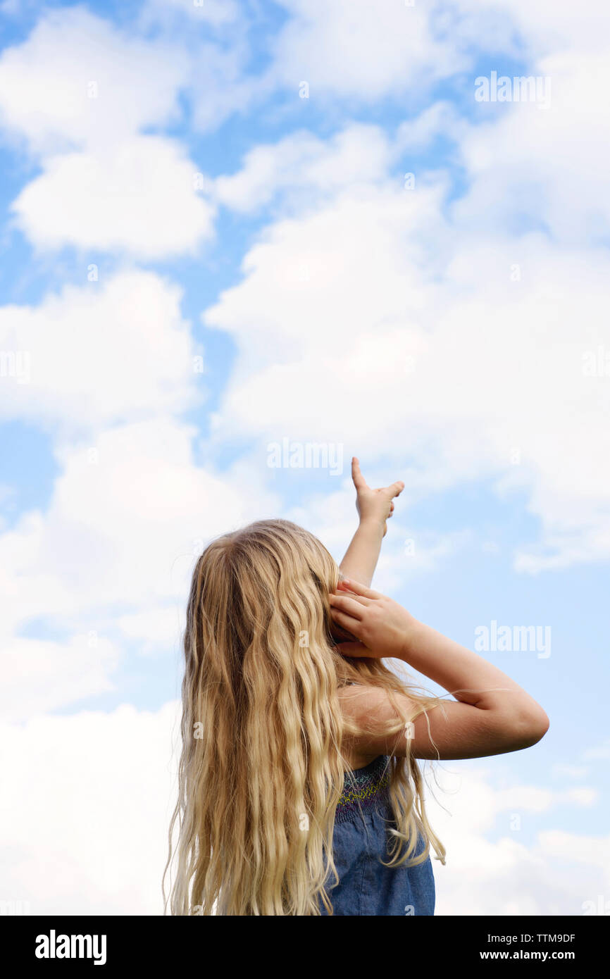Side view of girl pointing towards sky Stock Photo - Alamy