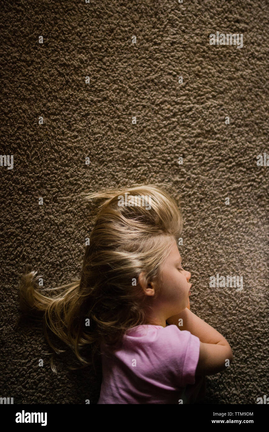 Overhead view of girl sleeping on rug at home Stock Photo - Alamy