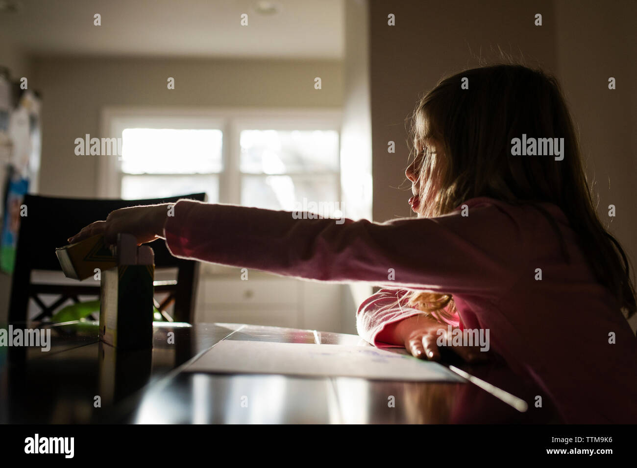 Side view of girl drawing on paper at home Stock Photo - Alamy