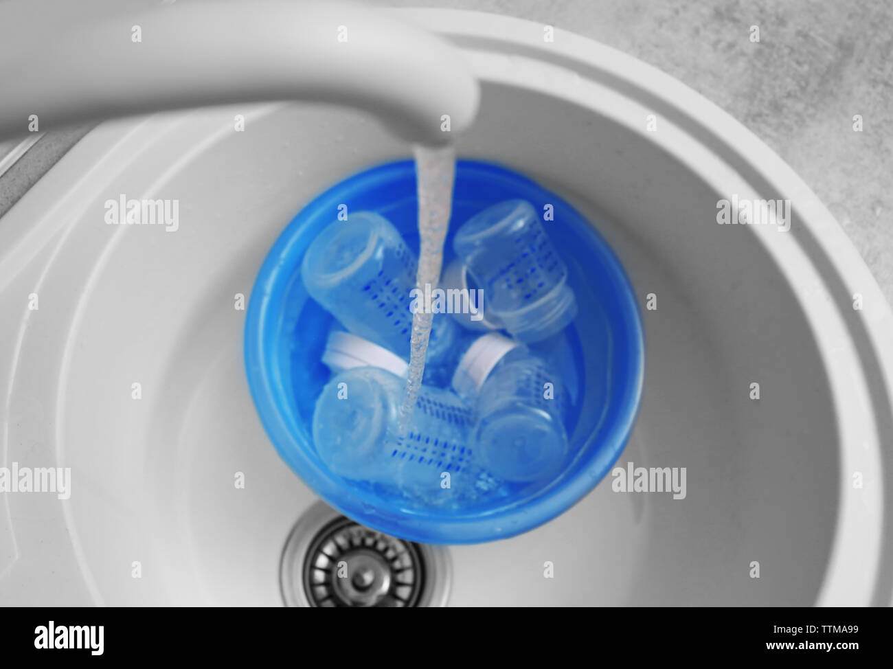 Sterilizing baby bottles in plastic blue basin Stock Photo - Alamy