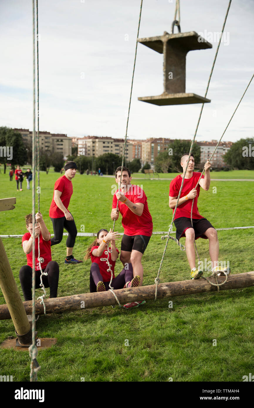 Team pulling ropes on field during race Stock Photo - Alamy