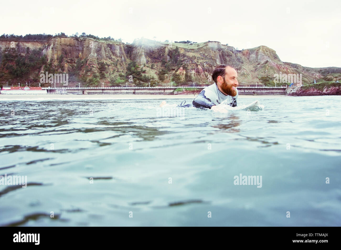 Happy male surfer lying on surfboard in sea Stock Photo - Alamy