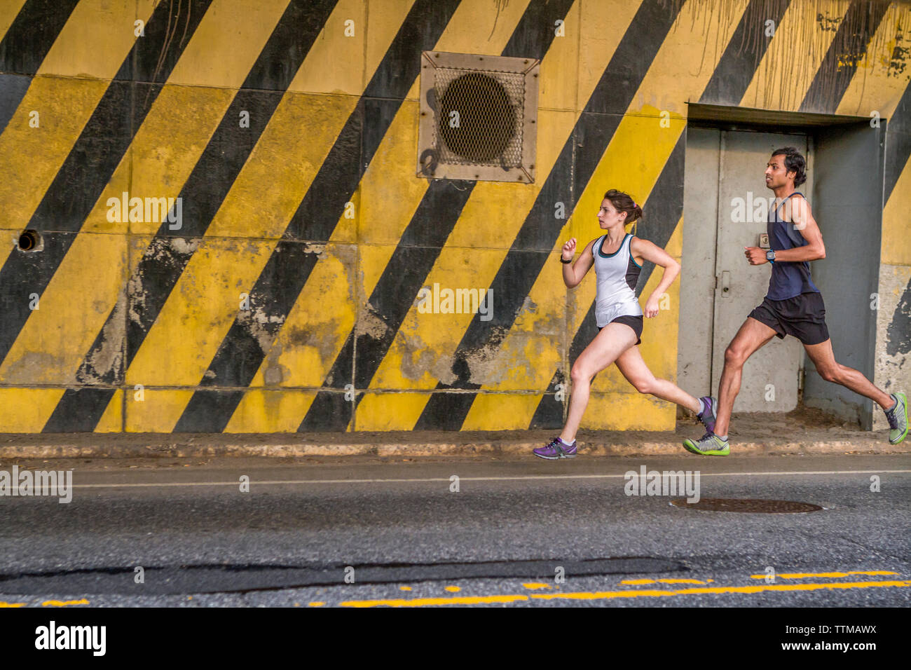 runners run on city street together in hazardous zone Stock Photo - Alamy