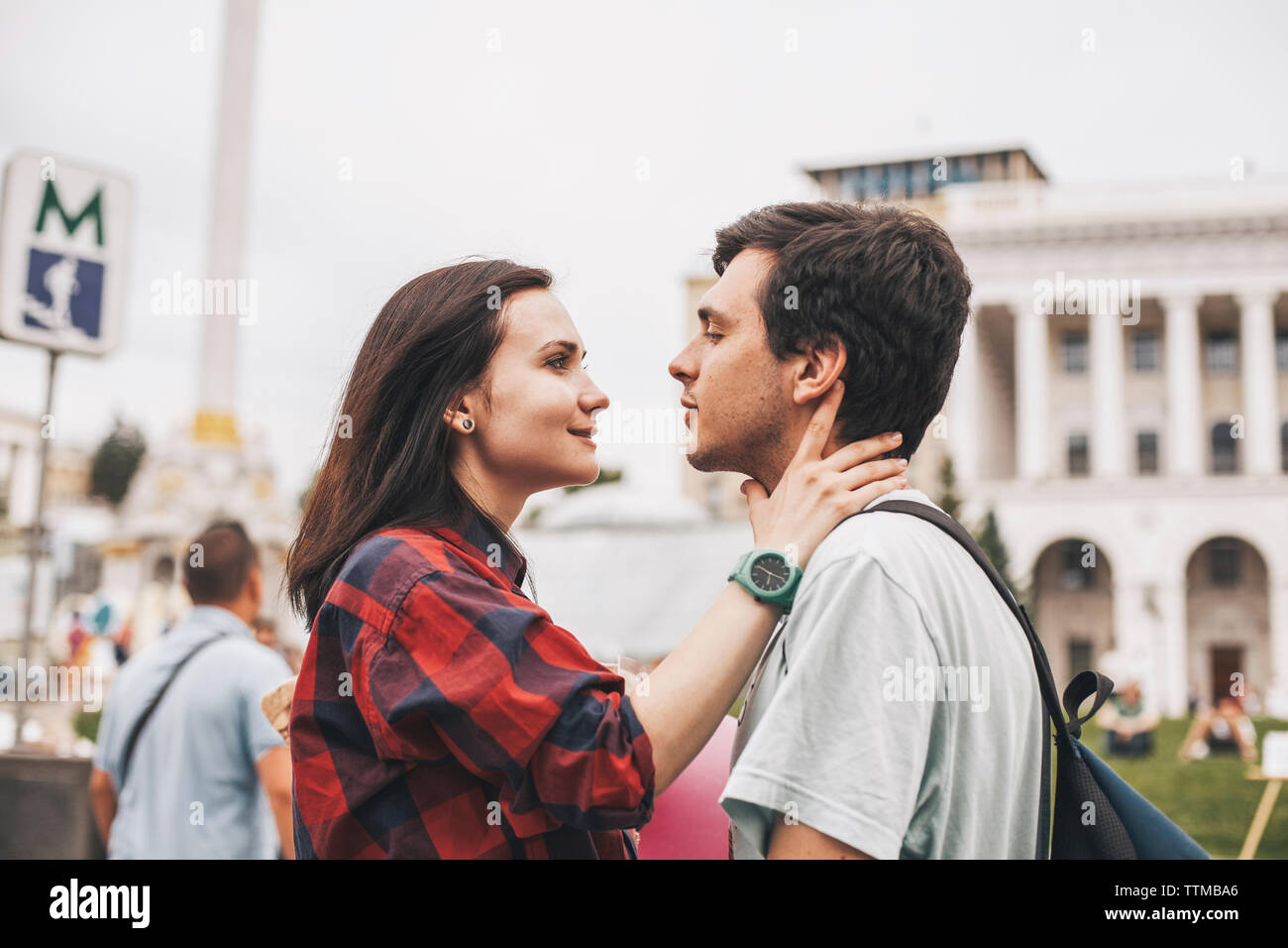 Side view of young couple looking each other face to face in city Stock ...