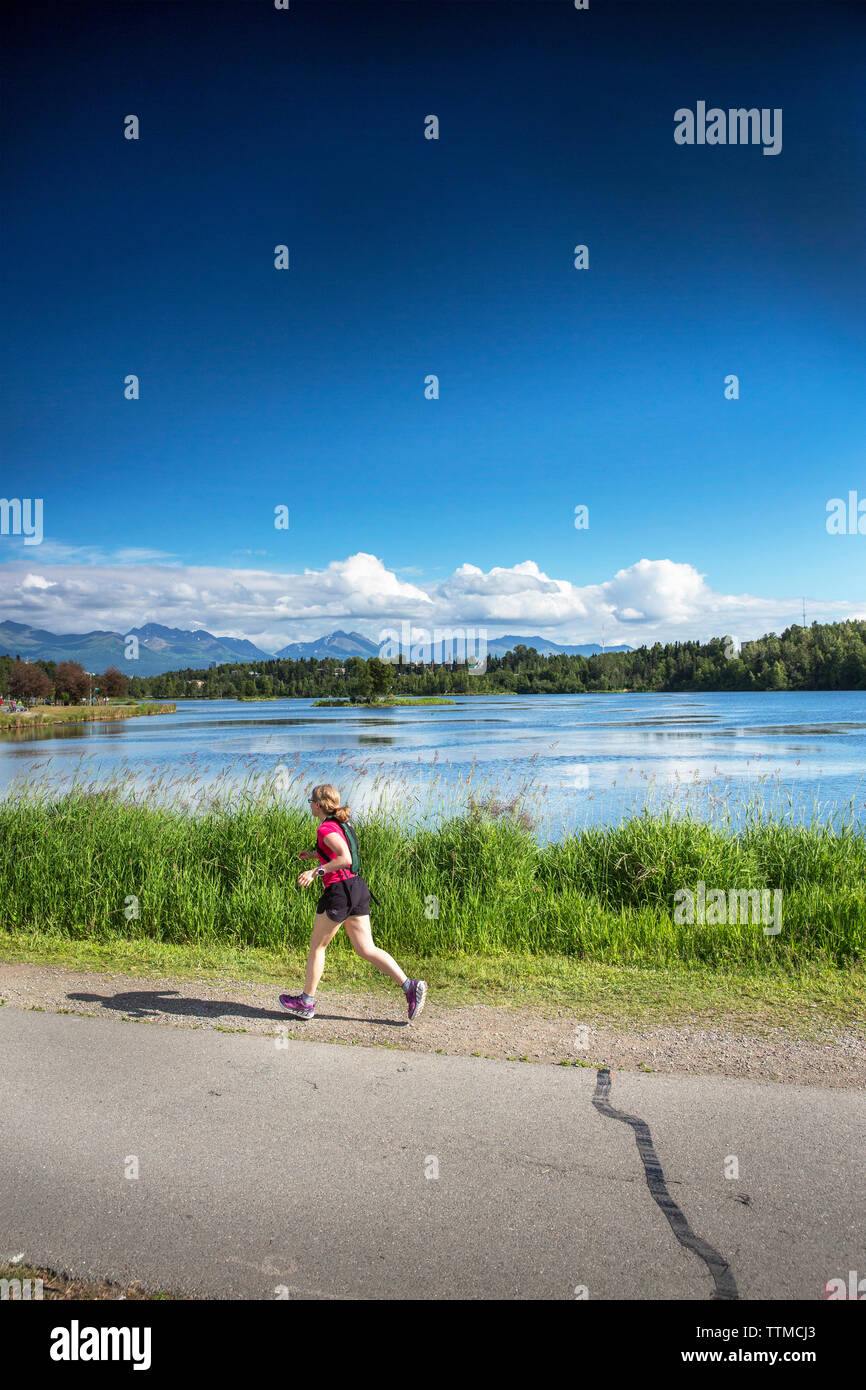 USA, Alaska, Anchorage, individuals run through Waterfront Park which ...