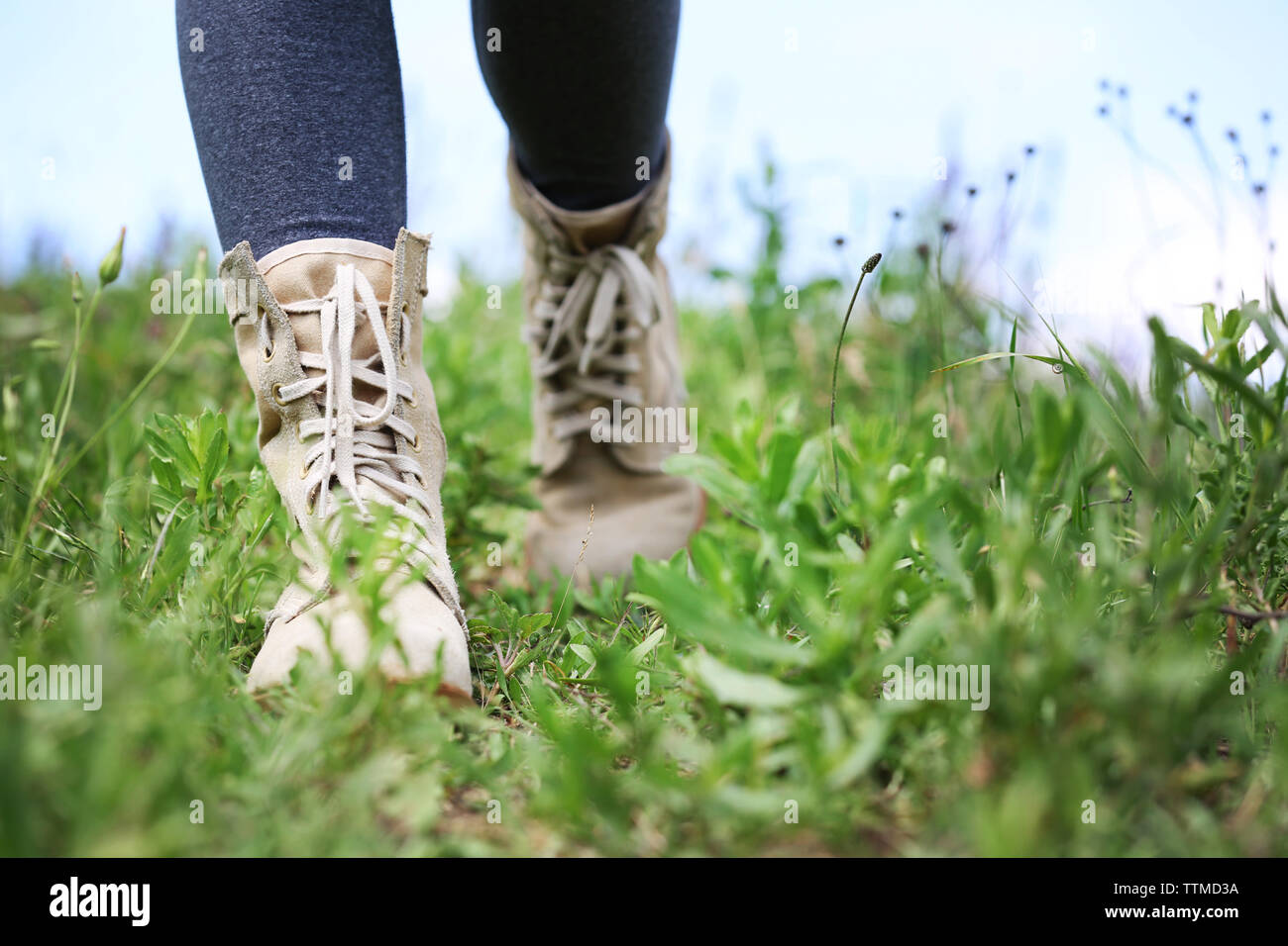 Female hiker legs with boots walking through meadow at sunny day Stock ...