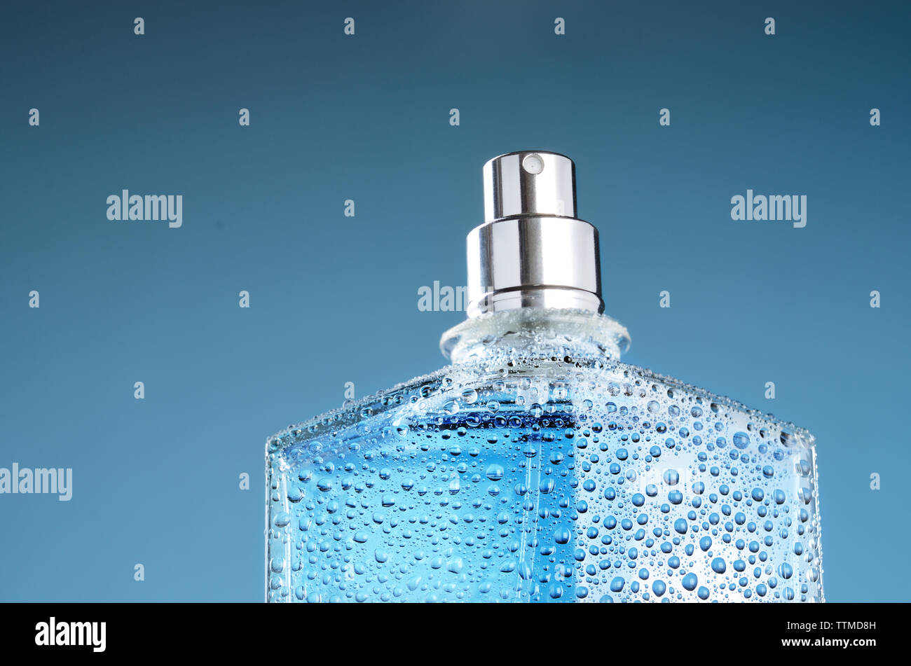 Perfume in blue bottle with water droplets Stock Photo - Alamy