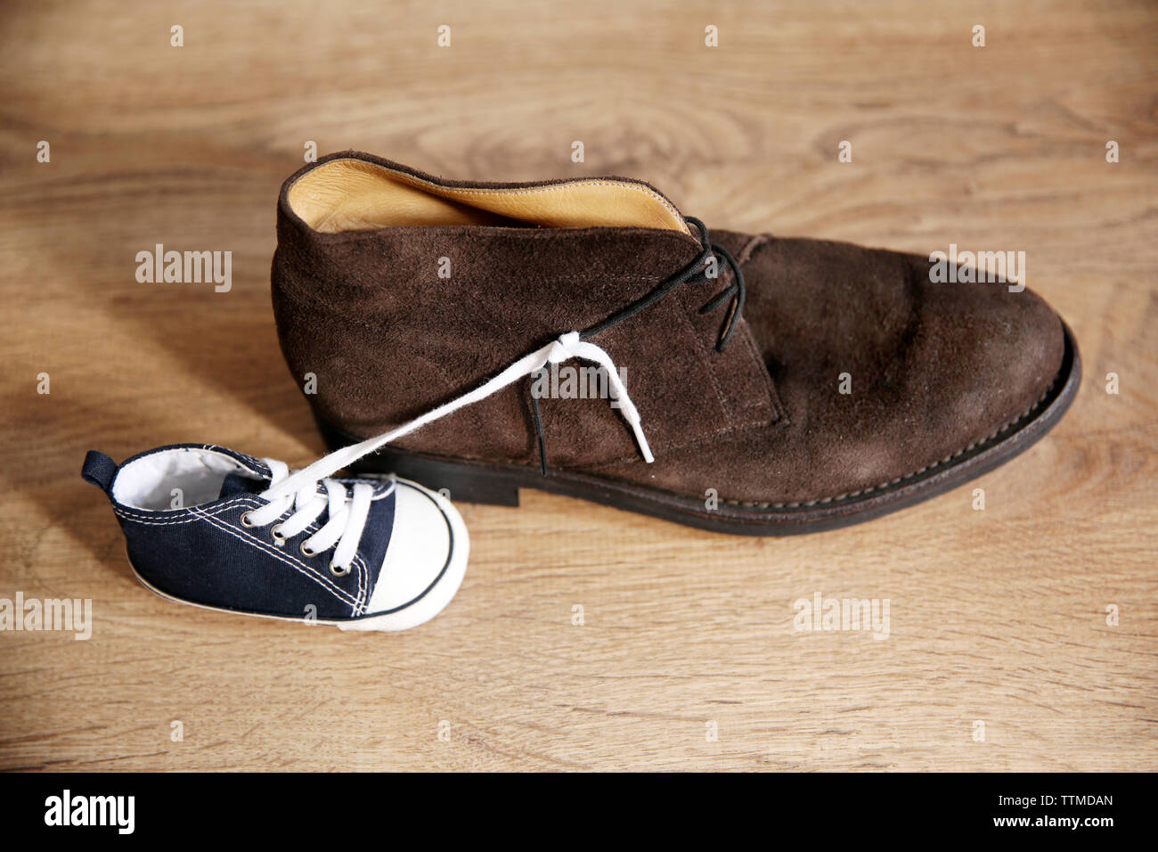 Big and small shoes on wooden background Stock Photo - Alamy