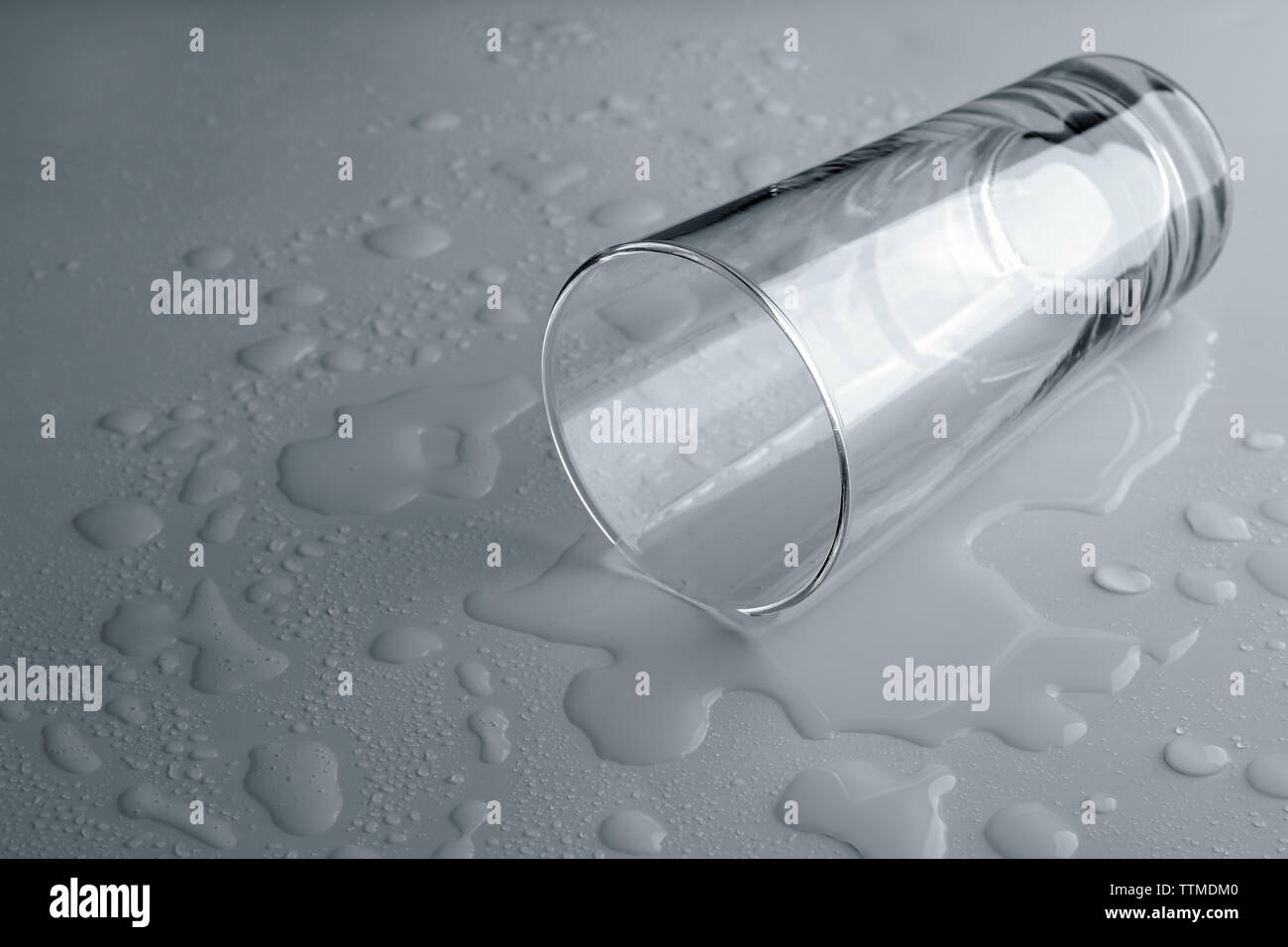 Glass with drops on light background Stock Photo - Alamy