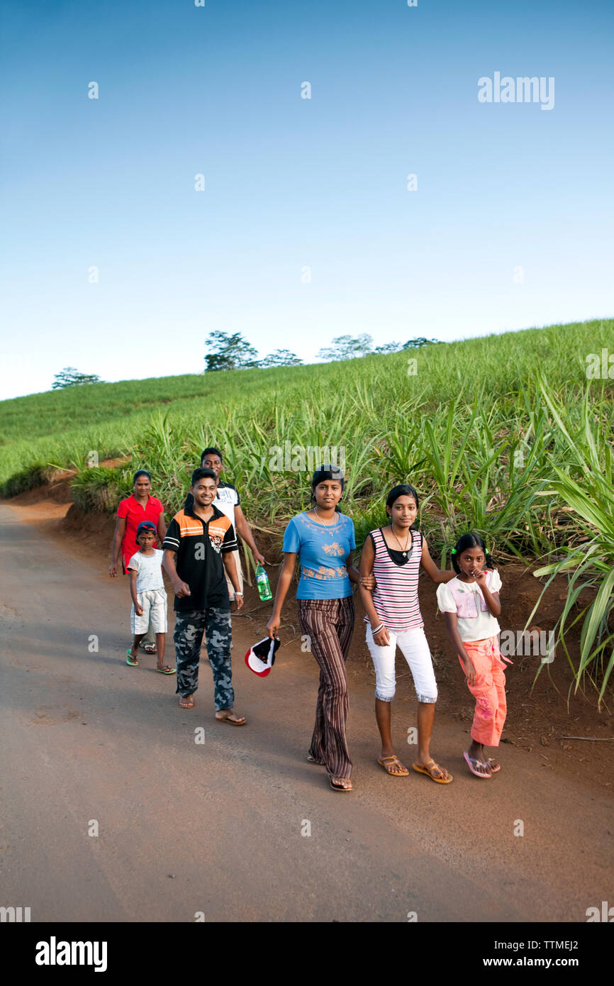MAURITIUS, Chamarel, a family walks down the road after a visit to see ...