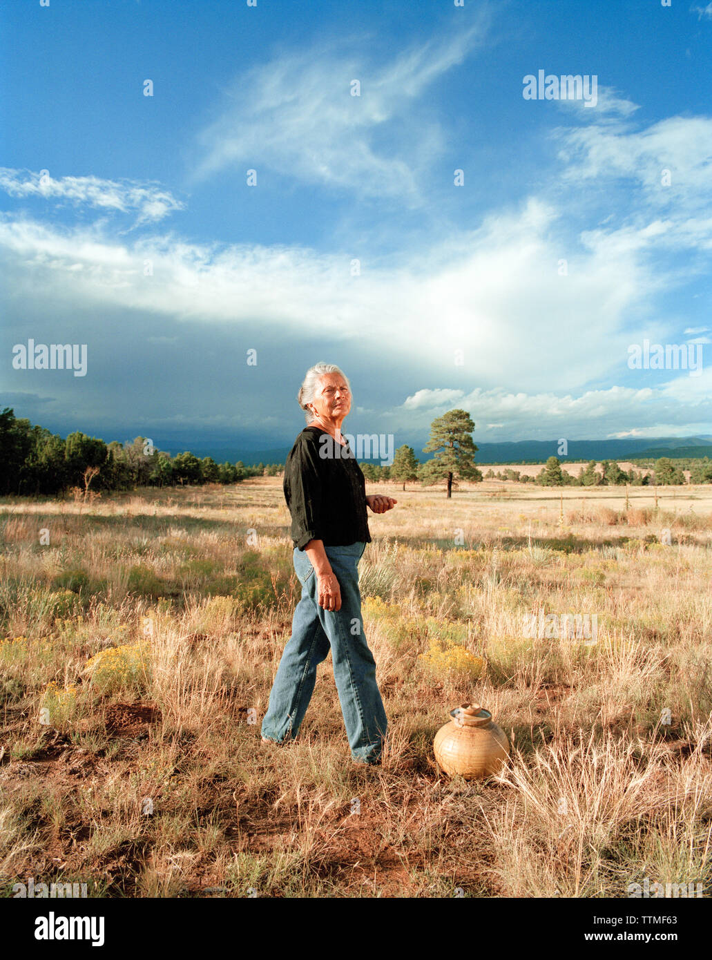 USA, New Mexico, beautiful Native American woman standing by a pot ...