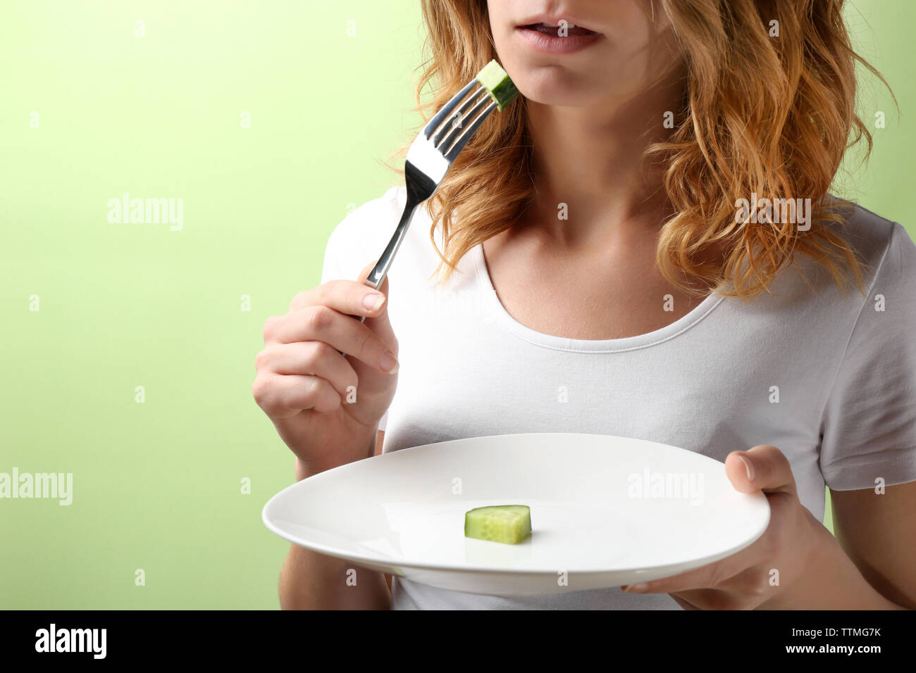 Woman dieting eating slice of cucumber hi-res stock photography and ...