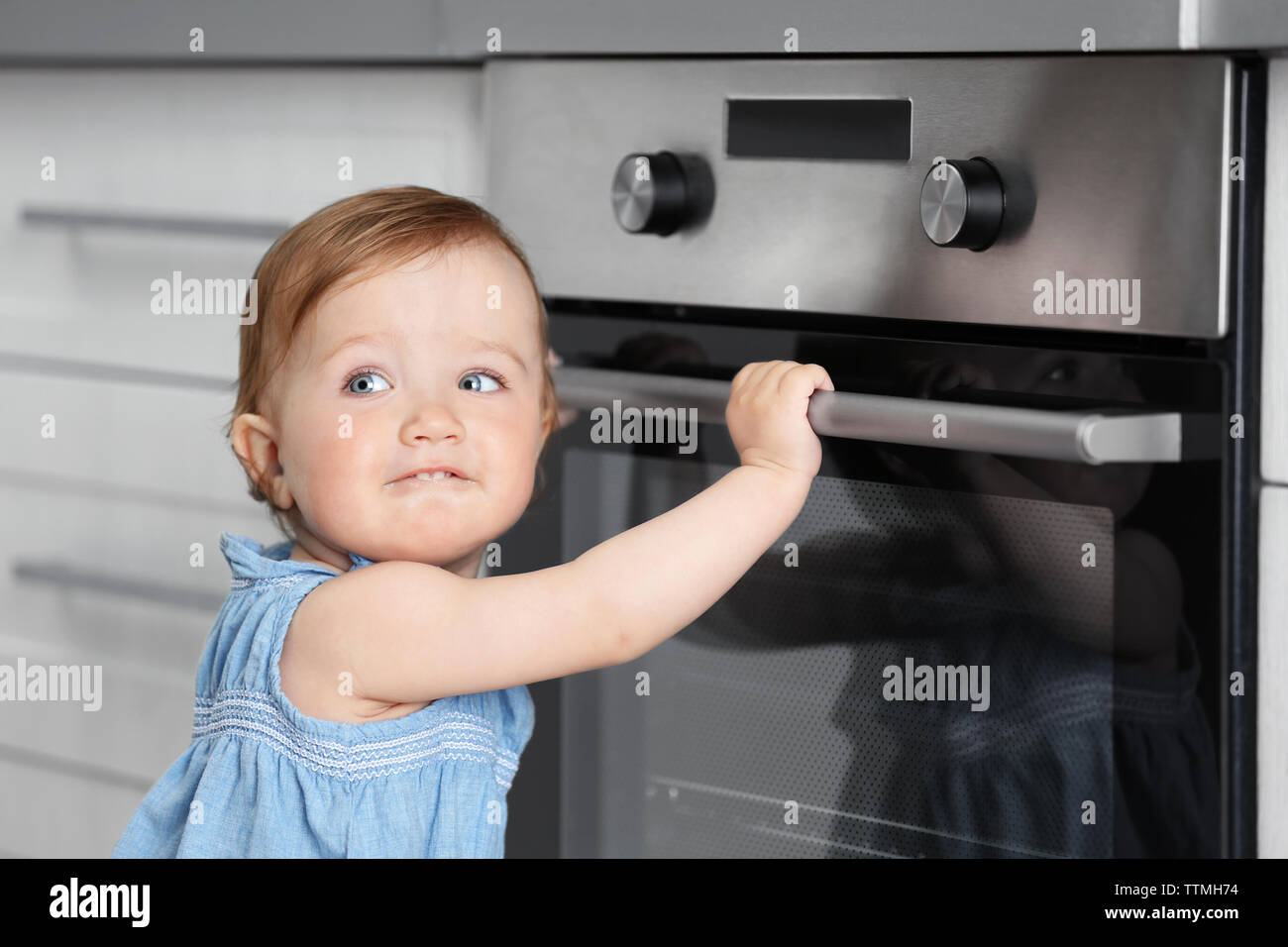 Child playing with electric oven Stock Photo - Alamy