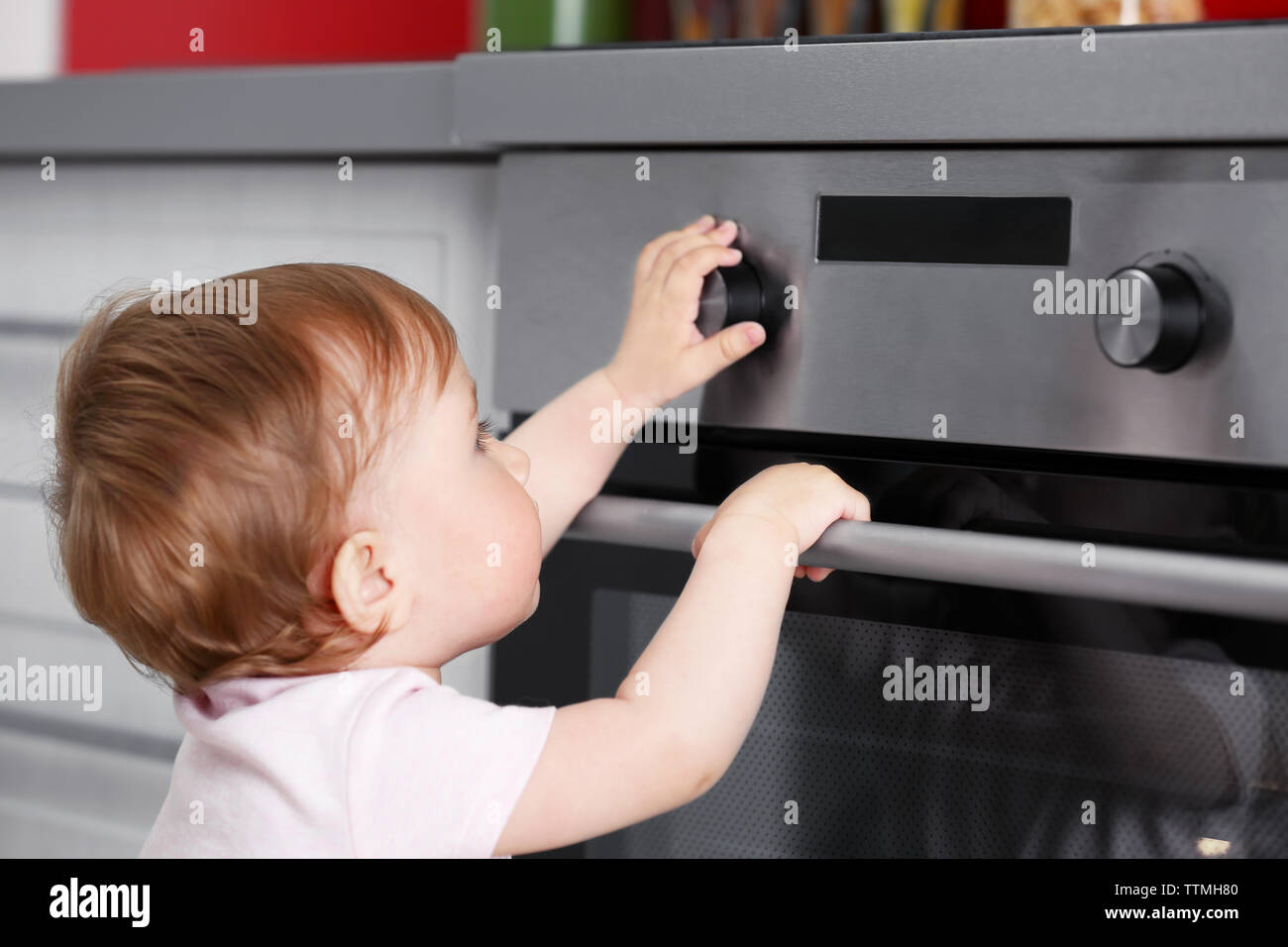 Child playing with electric oven Stock Photo - Alamy