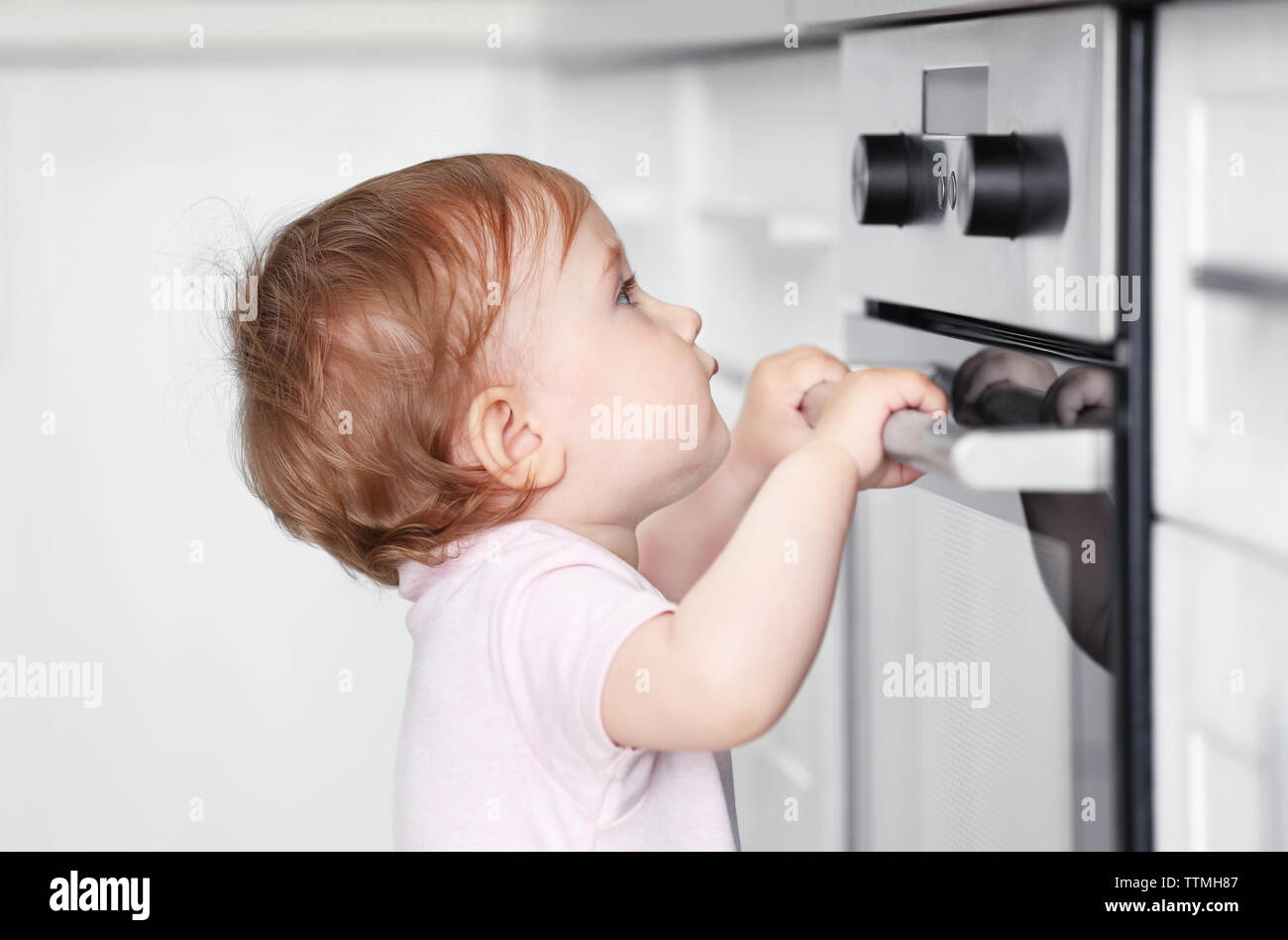 Child playing with electric oven Stock Photo - Alamy