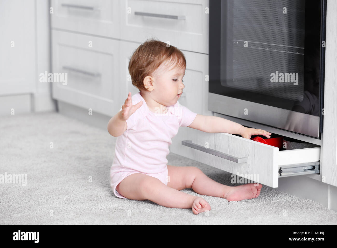 Little child playing with drawer Stock Photo - Alamy