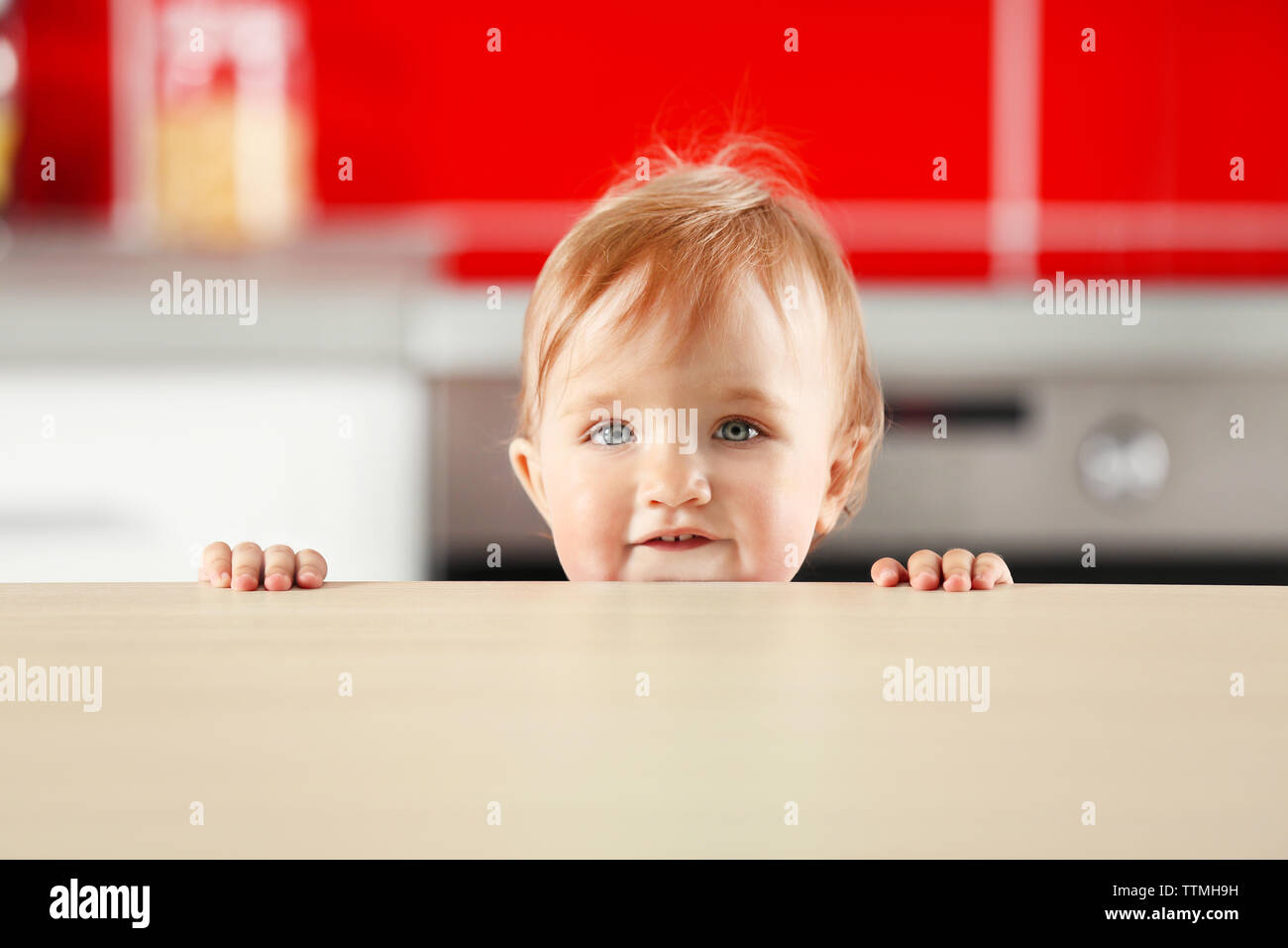Child looking over kitchen counter Stock Photo - Alamy