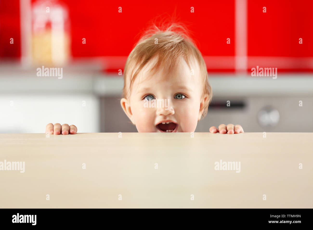 Child looking over kitchen counter Stock Photo - Alamy