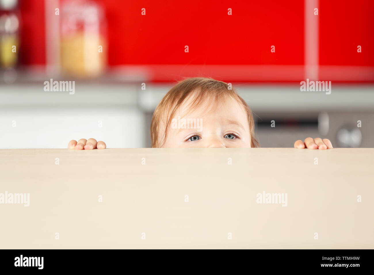 Child looking over kitchen counter Stock Photo - Alamy