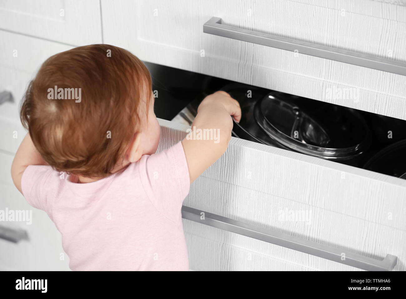 Little child playing with drawer Stock Photo - Alamy