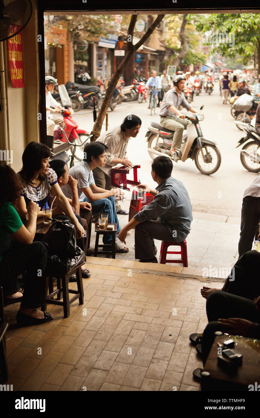 VIETNAM, Hanoi, friends socialize and drink coffee at a local coffee ...