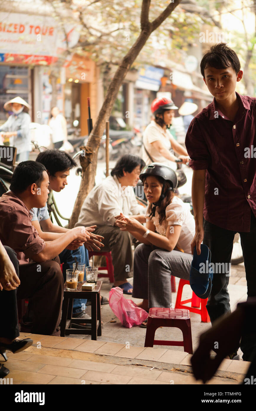 VIETNAM, Hanoi, friends socialize and drink coffee at a local coffee ...