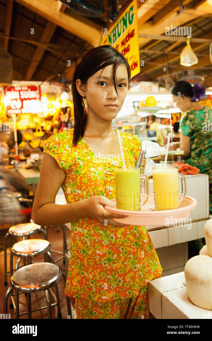 VIETNAM, Saigon, Ben Thanh Market, a young girl delivers avocado and ...
